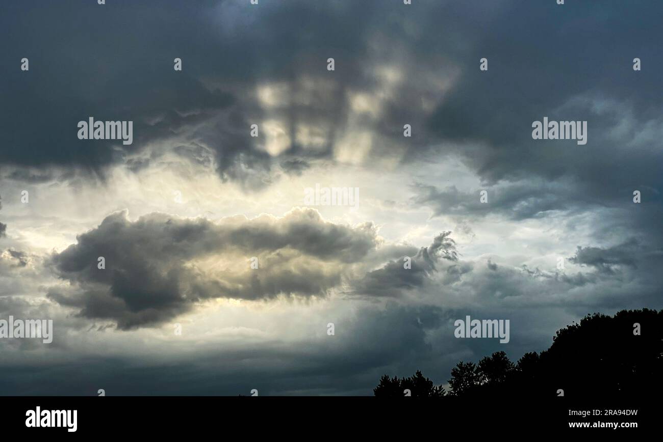 Sun rays shining through dark clouds, colorful dramatic sky with cloud ...