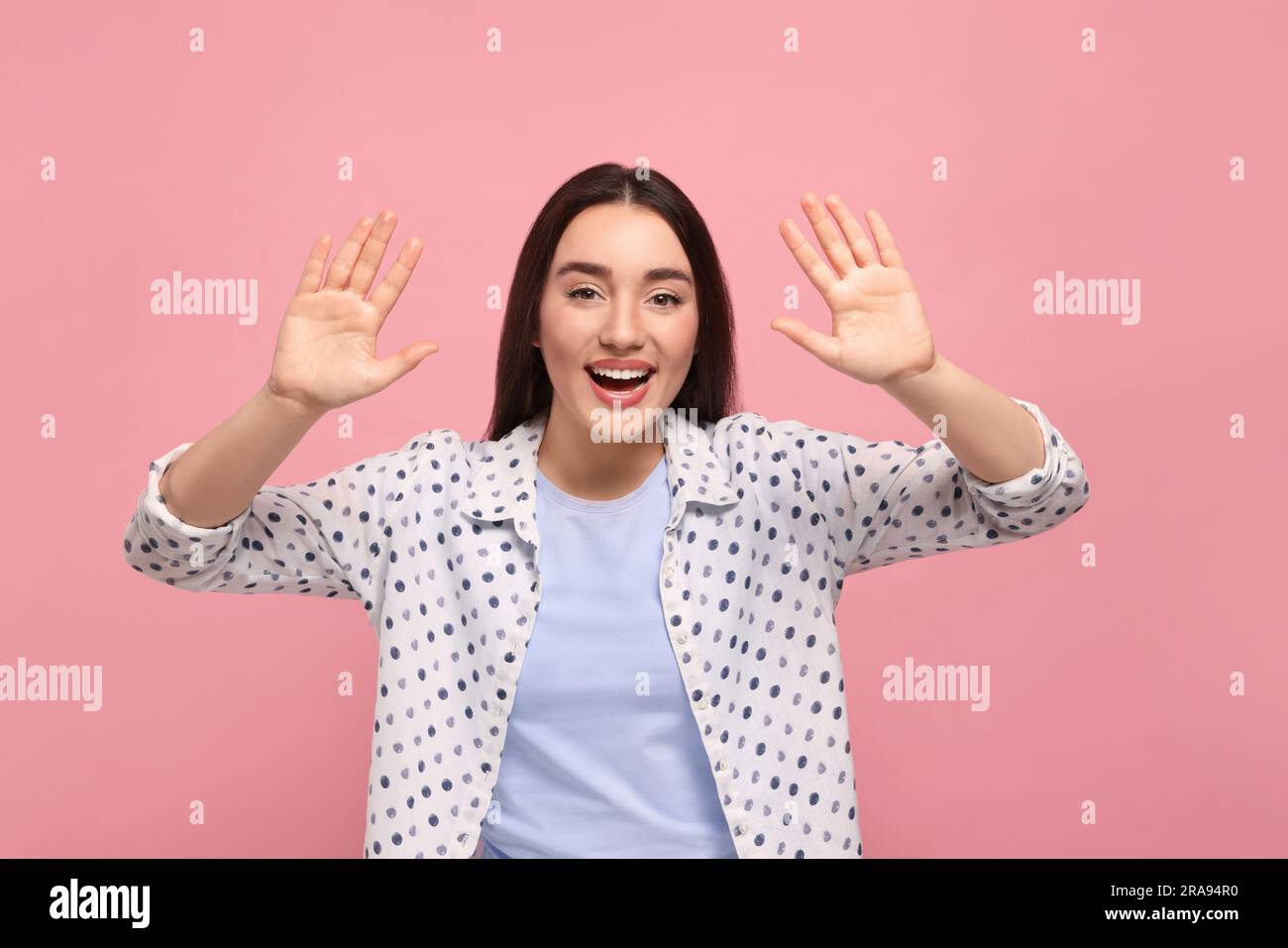 Happy woman giving high five with both hands on pink background Stock ...