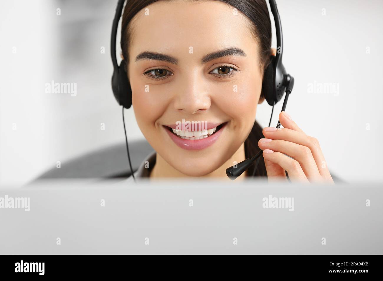 Hotline operator with headset working on computer in office Stock Photo ...