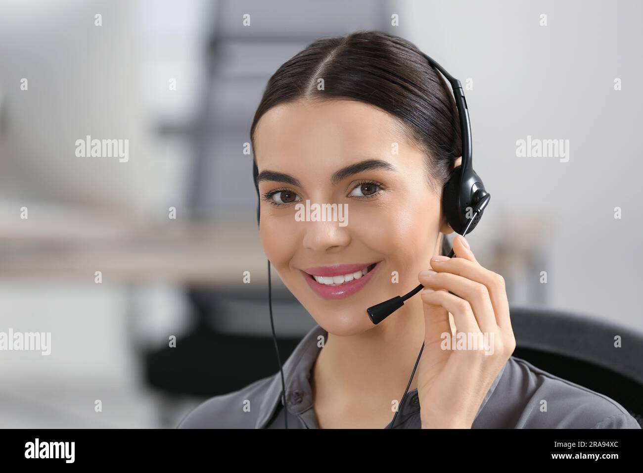 Hotline operator with headset working in office Stock Photo - Alamy