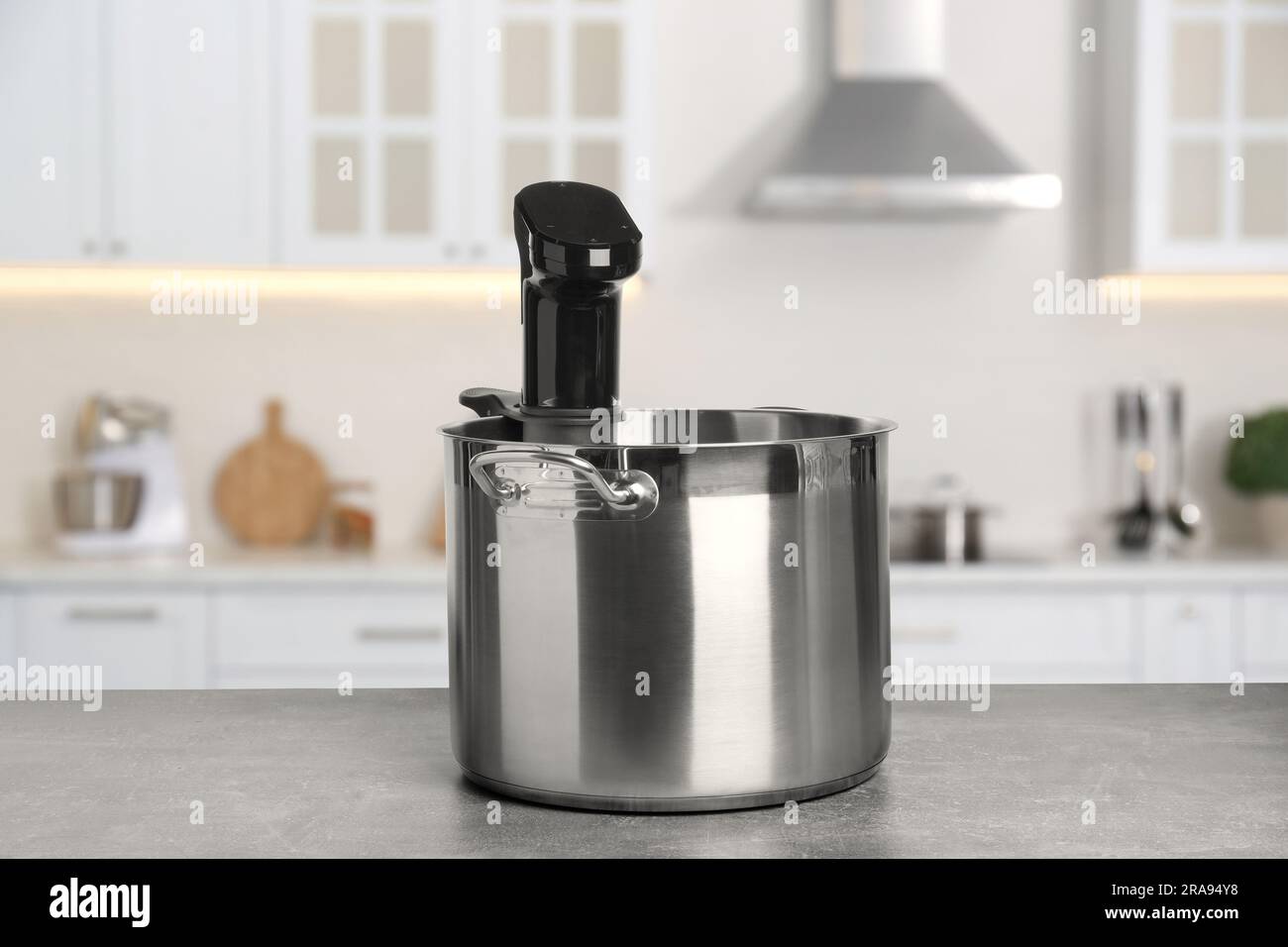Sous vide cooker in pot on light table in kitchen. Thermal immersion ...