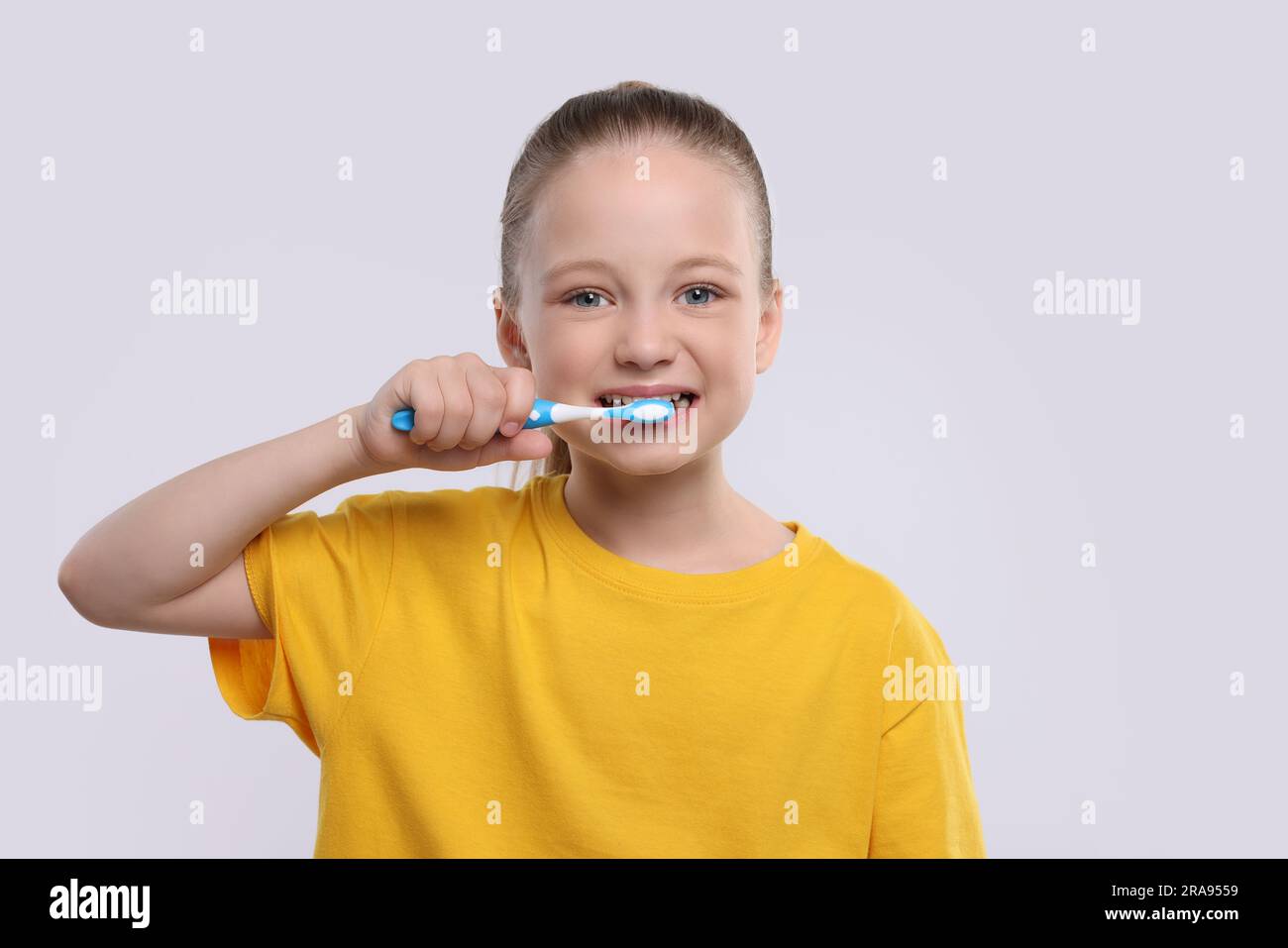 Happy girl brushing her teeth with toothbrush on white background Stock ...
