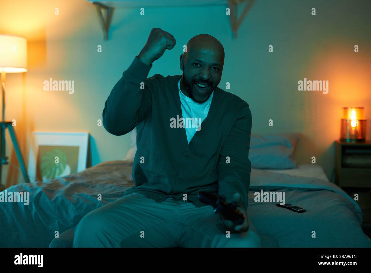 Front view portrait of excited adult black man playing video games in ...