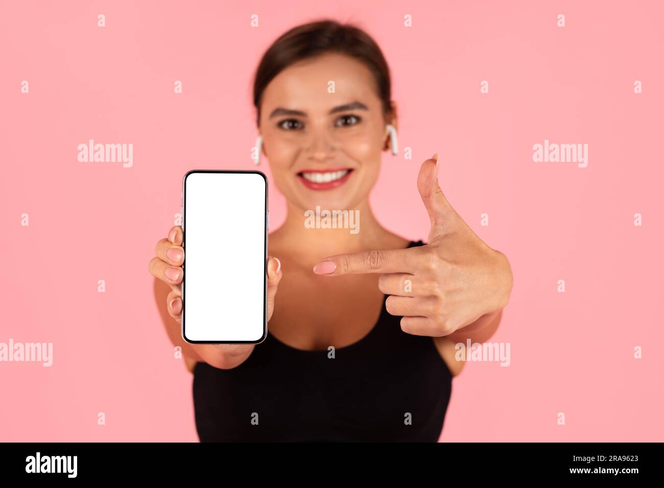 Sporty Young Lady Pointing At Big Blank Smartphone In Her Hand Stock ...