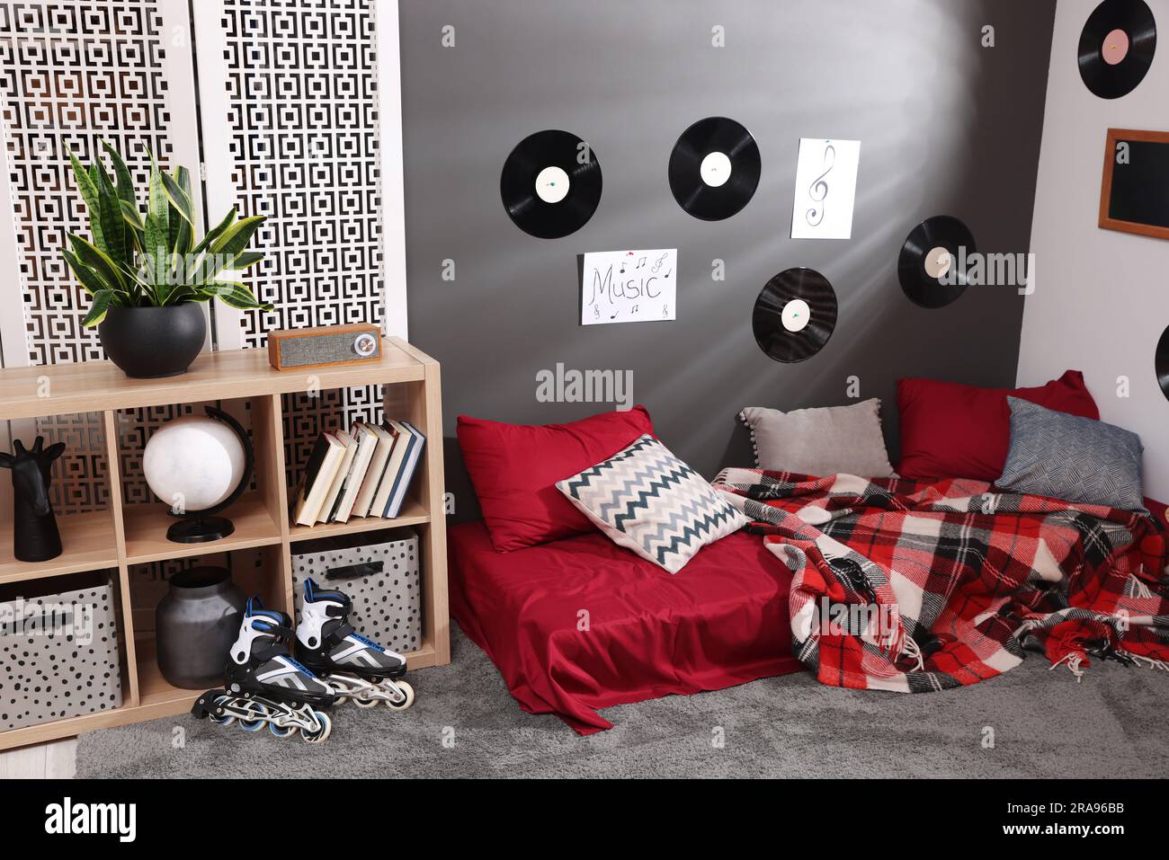 Stylish teenager's room with bed, wooden rack and vinyl records on wall ...