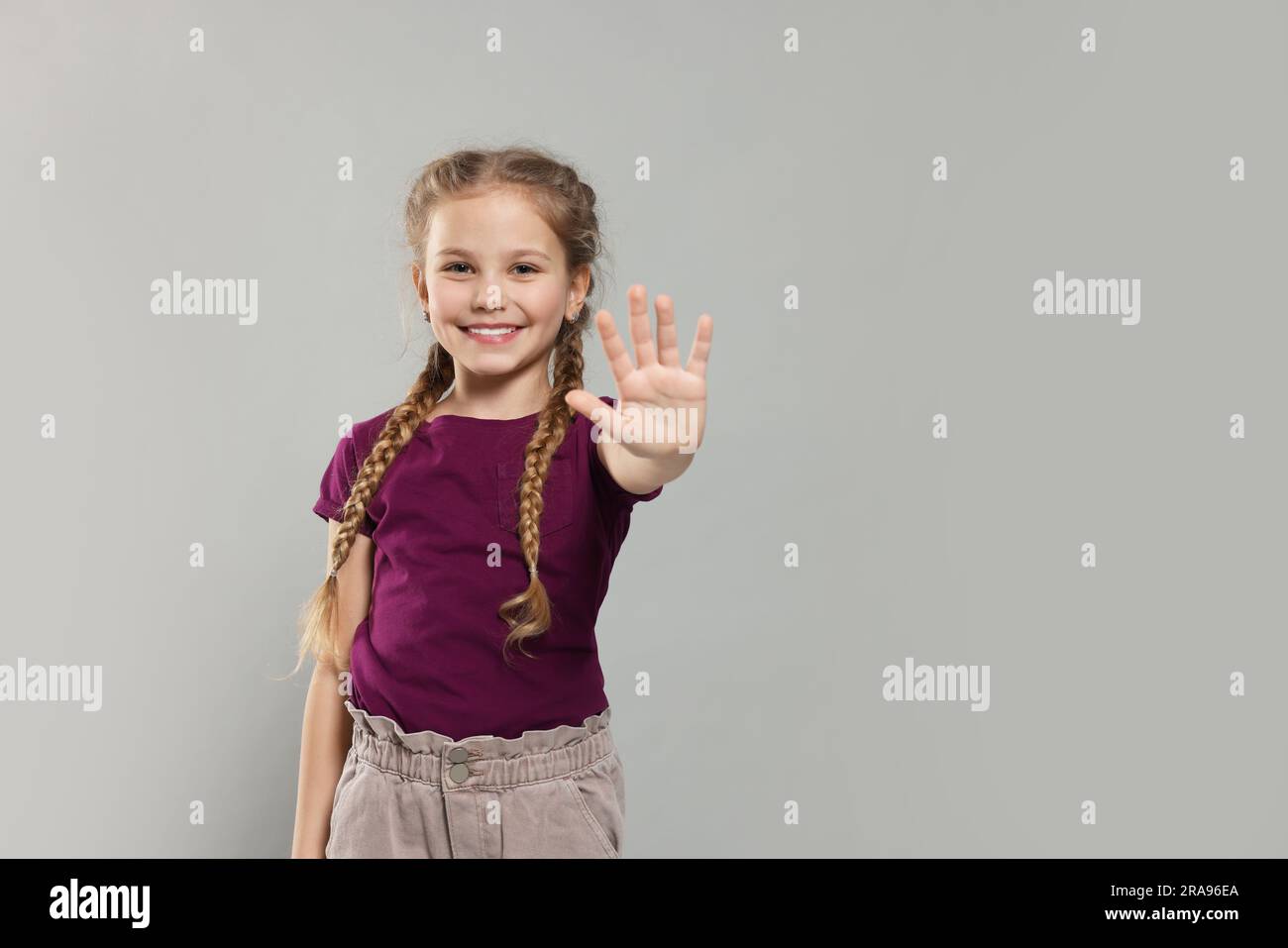 Happy girl giving high five on light grey background, space for text ...