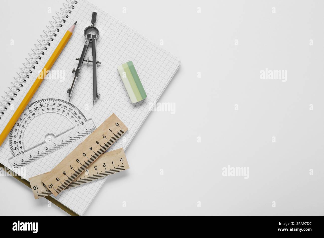 Different rulers, compass, pencil and notebook on white background, top ...