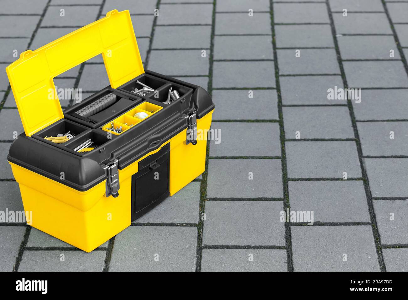 Plastic box with different furniture fittings on street tiles outdoors, space for text Stock ...