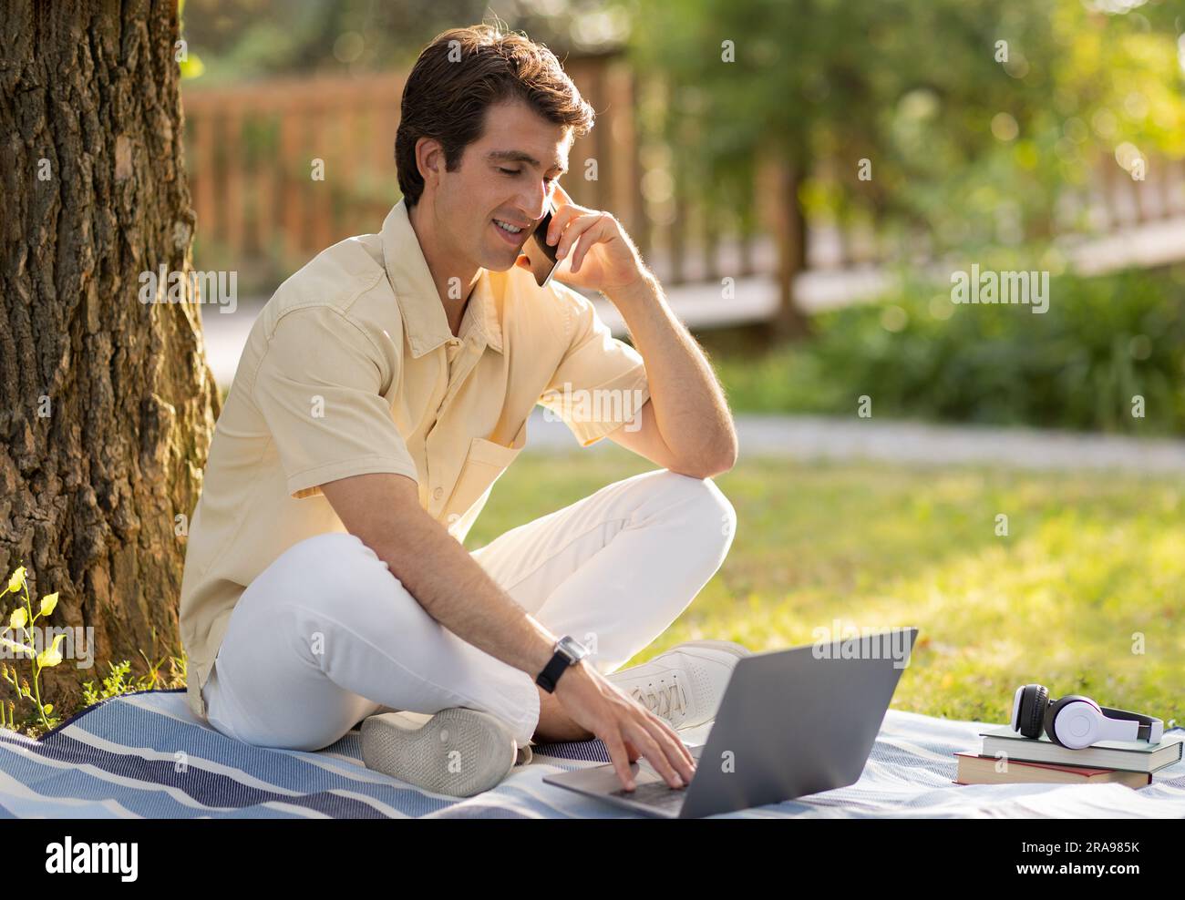 Young entrepreneur working at public park, have phone call Stock Photo ...