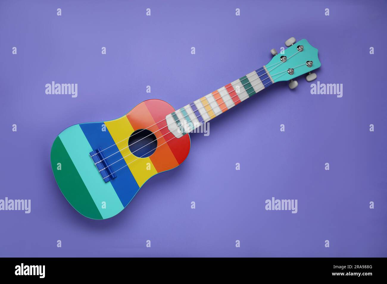 Colorful ukulele on purple background, top view. String musical ...