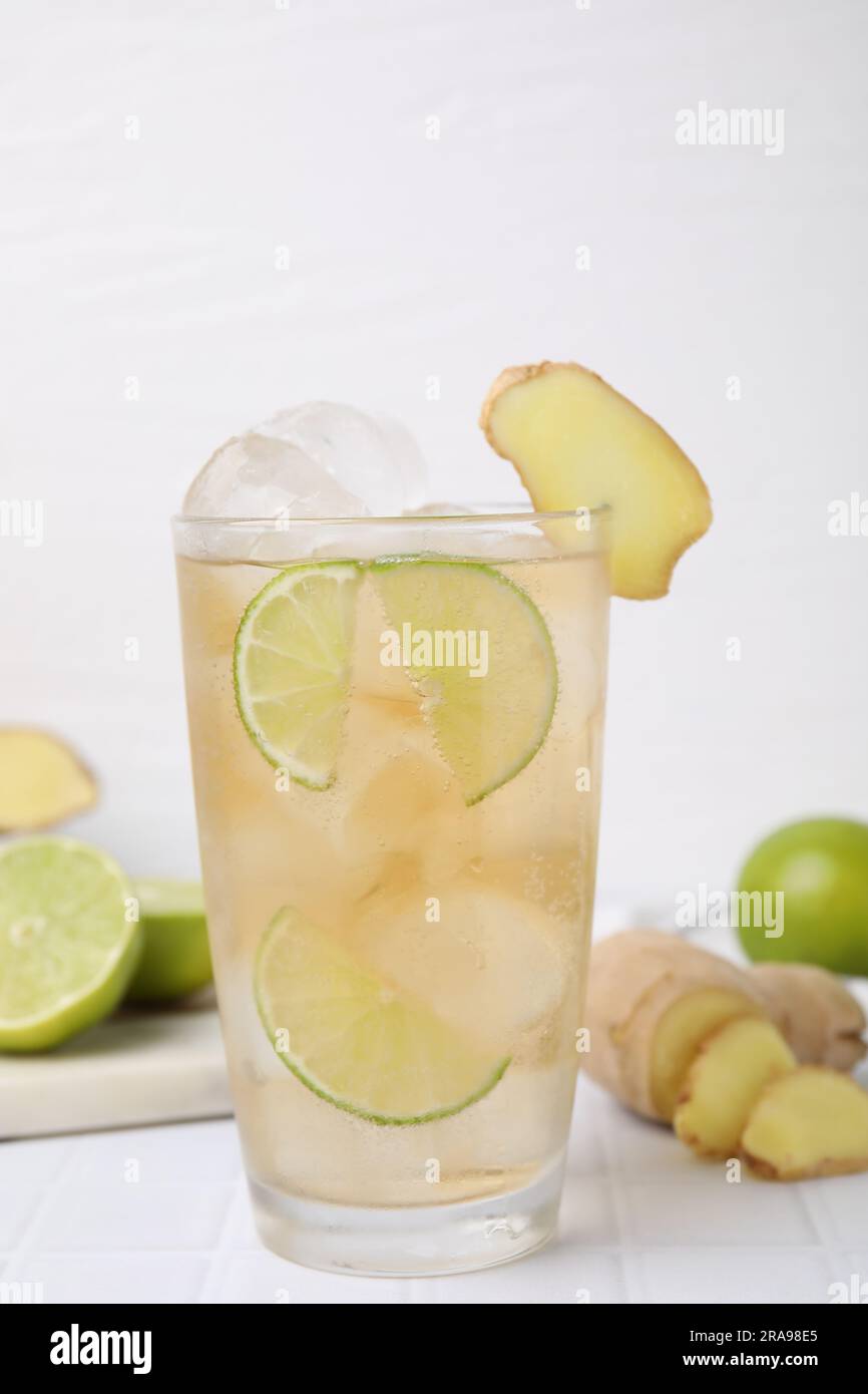 Glass of tasty ginger ale with ice cubes and ingredients on white tiled table Stock Photo - Alamy