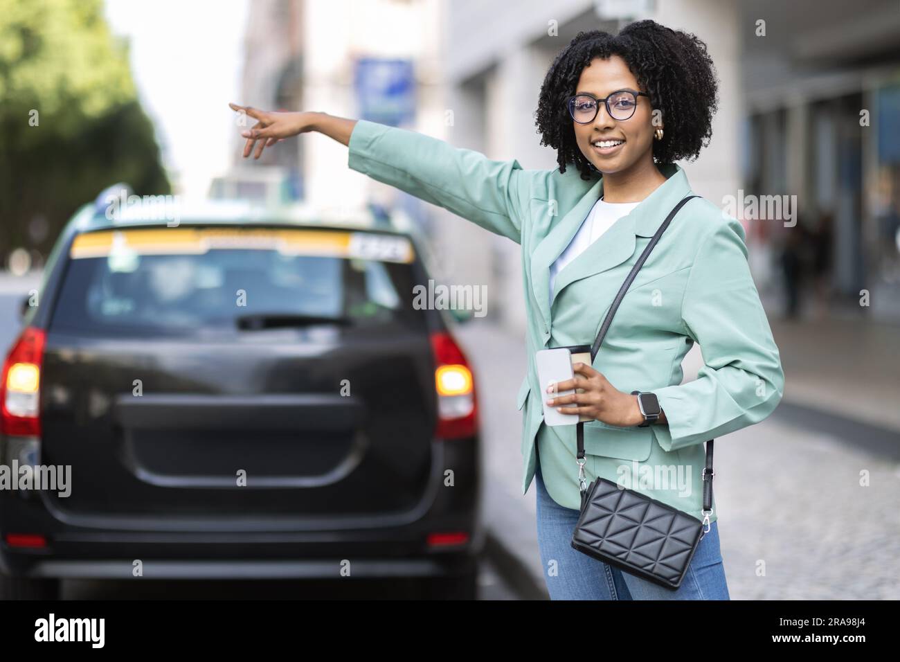 Attractive young black woman going to office, catching taxi Stock Photo ...