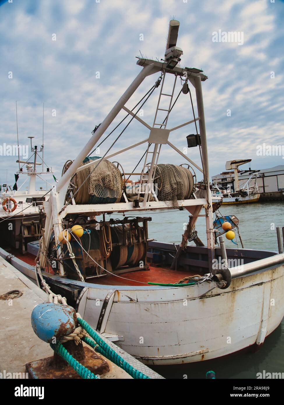 View of the industrial harbor: an old rusty fishing boat moored at the ...
