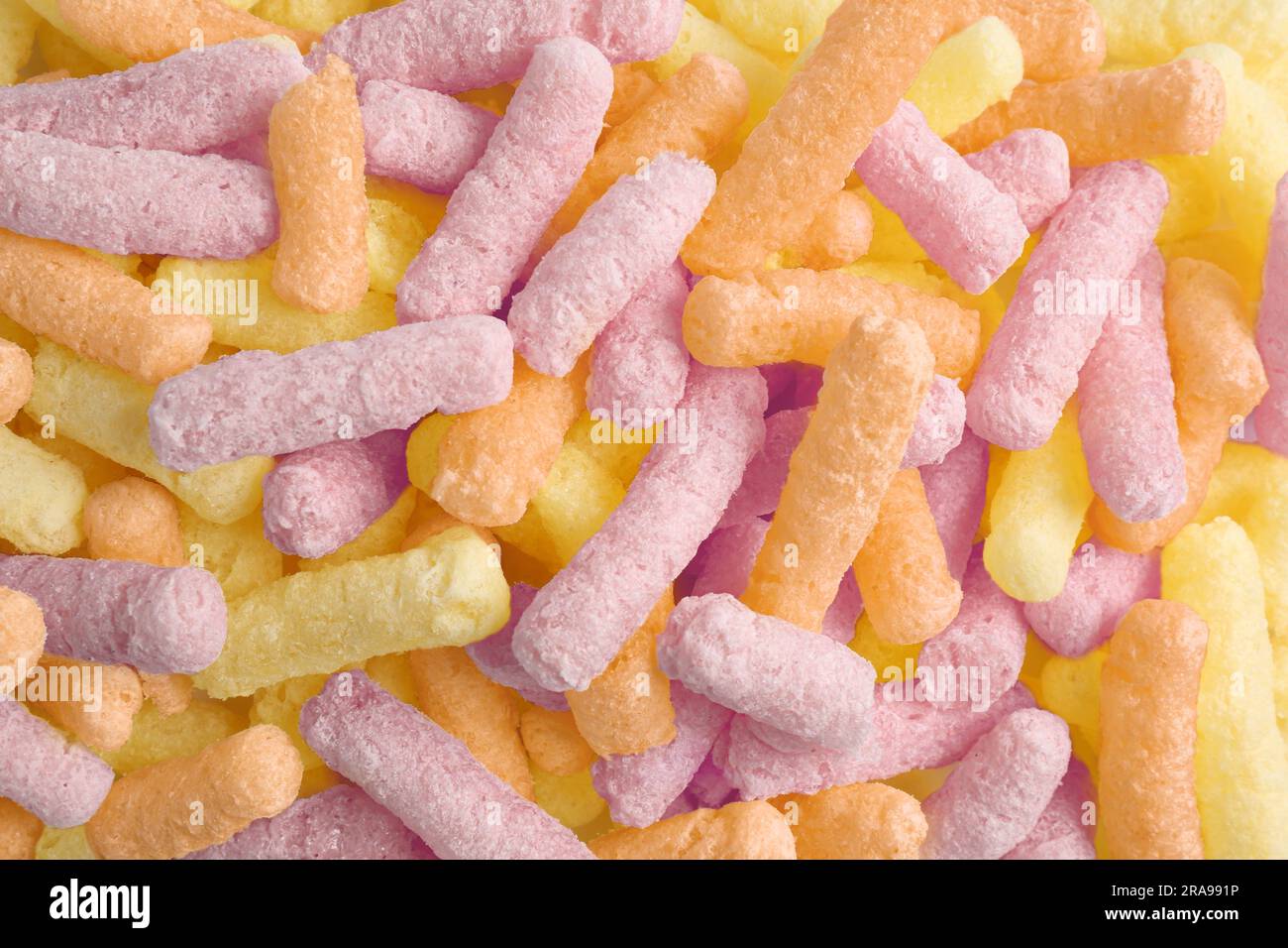 Many colorful corn puffs as background, top view Stock Photo - Alamy