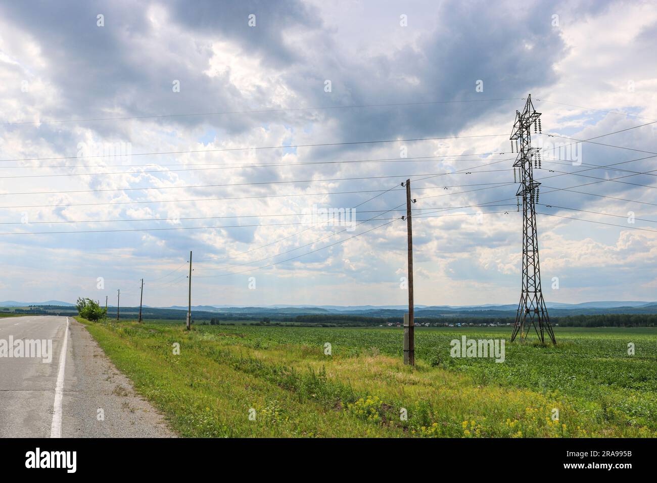 Power transmission towers over a rural field in the countryside. Gloomy ...