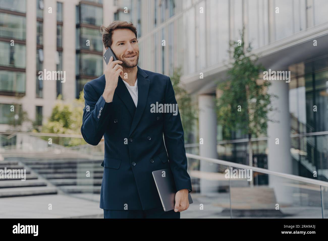 Handsome entrepreneur communicates, uses tech, dressed formal, poses ...