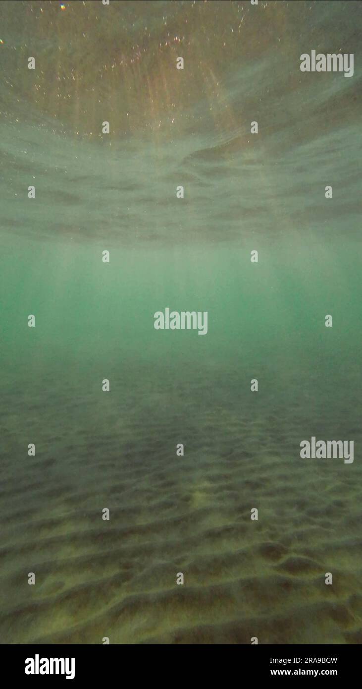 Low angle wide shot sun rays penetrating surface of water in the ...