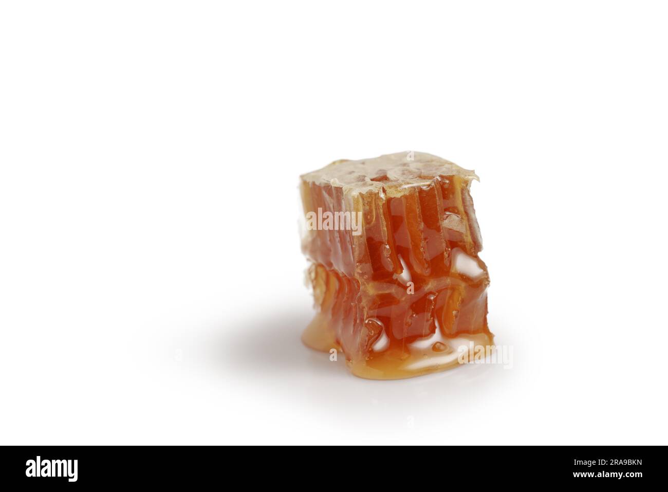 Honeycomb piece with honey puddle isoladet on white background, shallow ...