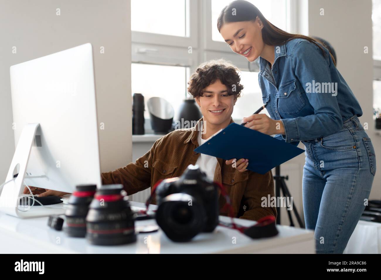 Photographer and his assistant working together with computer, planning ...