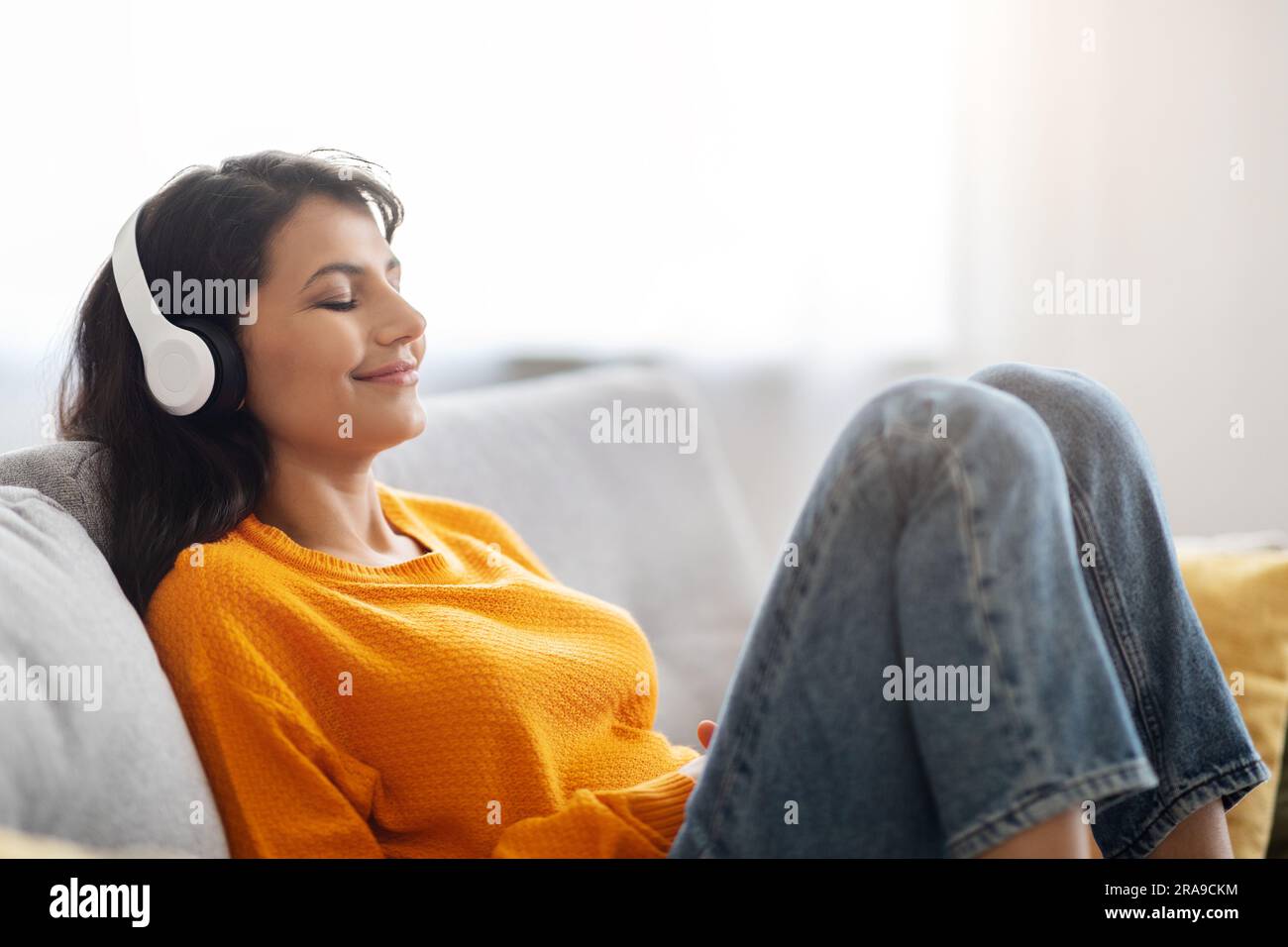 Relaxed peaceful eastern woman listening to music at home Stock Photo ...
