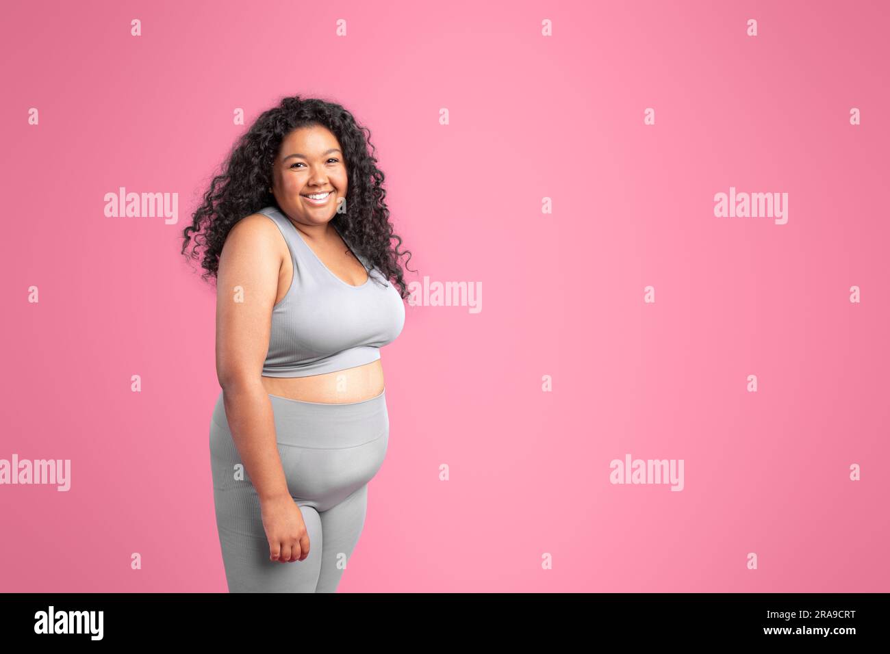 Portrait of body positive black lady in sports top bra and leggings ...