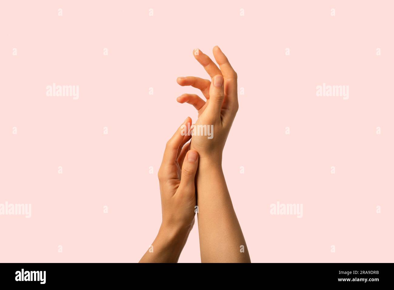 Beauty hands gently touching soft moisturized skin on pink background ...