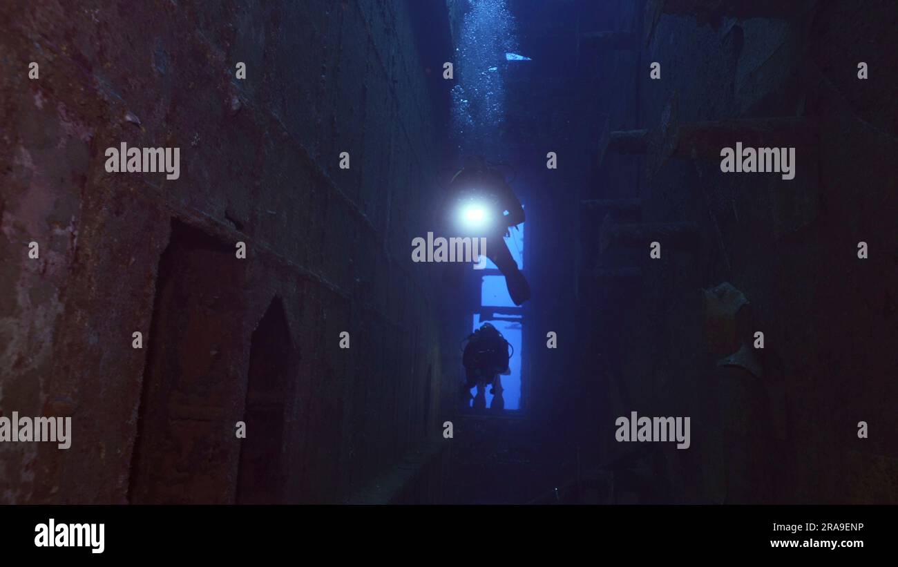 Scuba diver with lantern floats inside of ferry Salem Express shipwreck ...