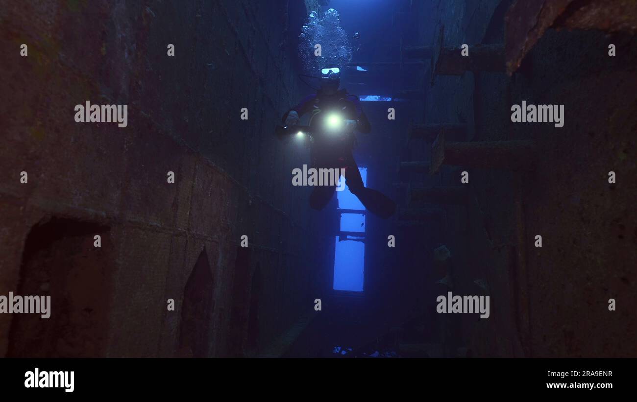 Scuba diver with lantern floats inside of ferry Salem Express shipwreck ...