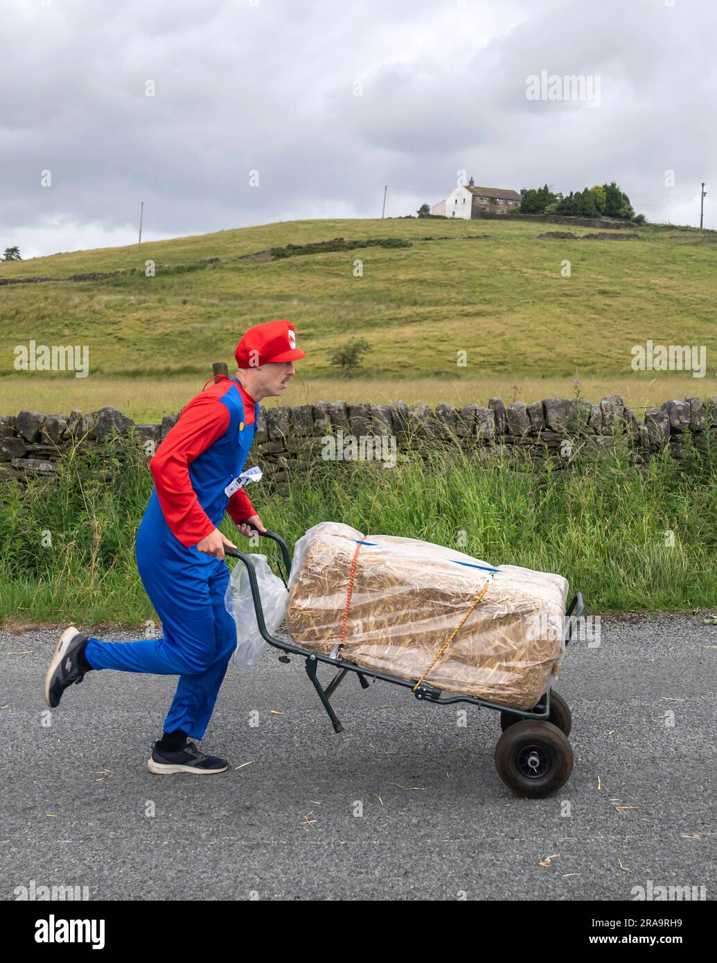 A competitor takes part on the Oxenhope Straw Race in West Yorkshire, a ...