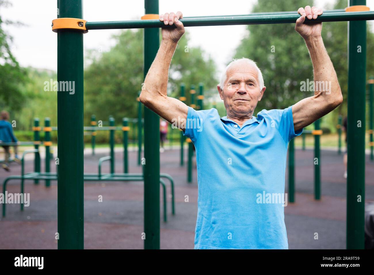 mature cheerful pensioner man doing physical exercises on sports ...