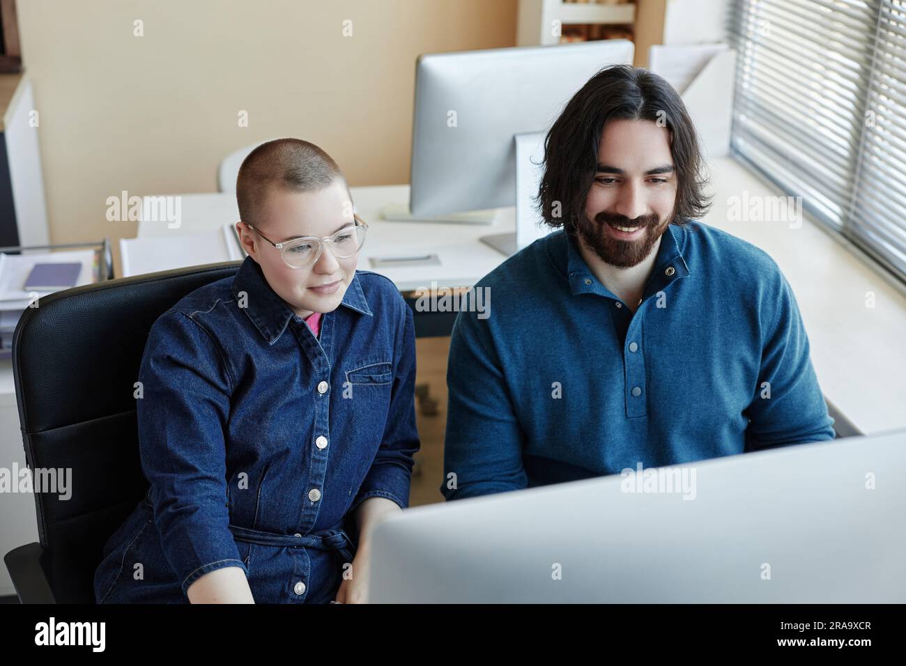 Two young professional IT engineers sitting in front of computer screen ... Two young professional IT engineers sitting in front of computer screen ...