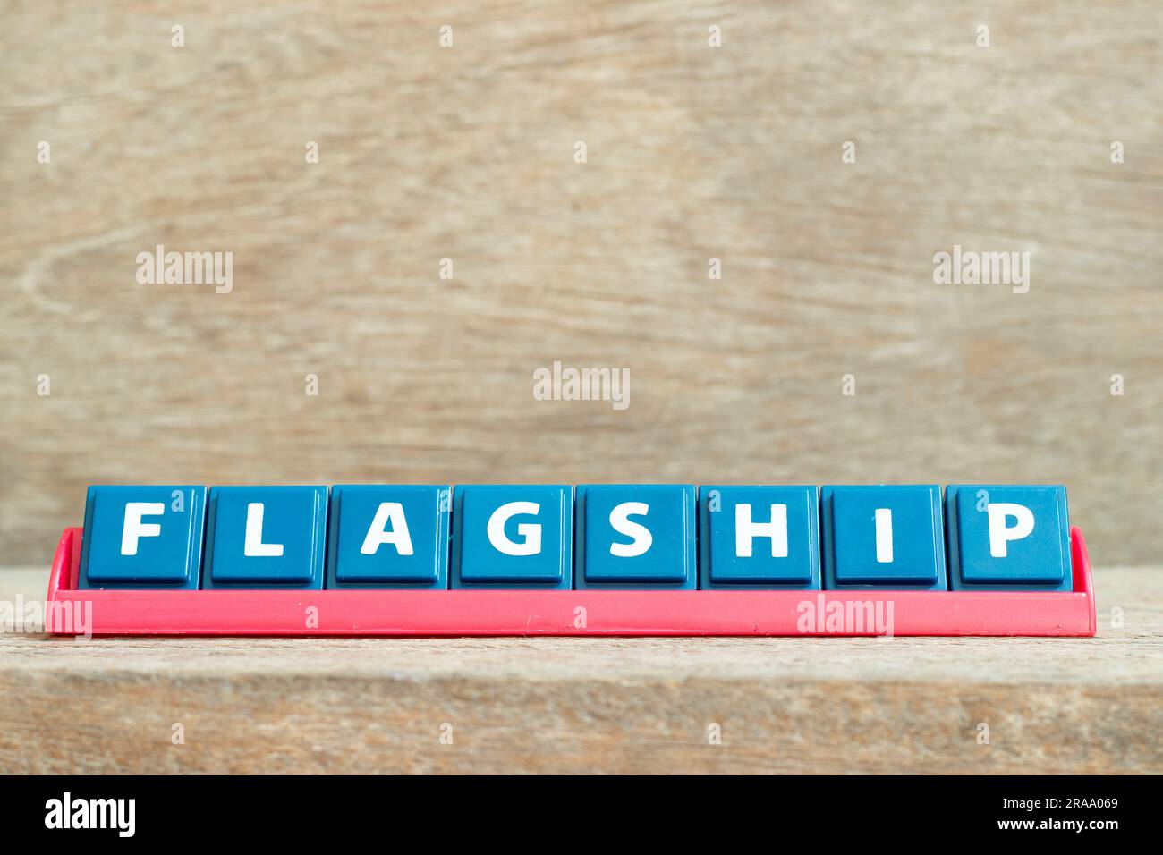 Tile alphabet letter with word flagship in red color rack on wood ...
