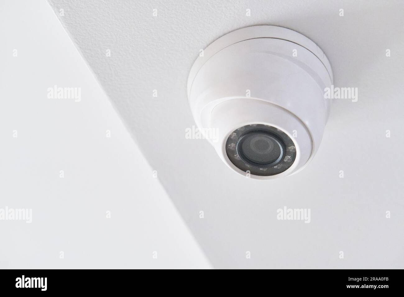 Cctv on white ceiling in modern building Stock Photo - Alamy