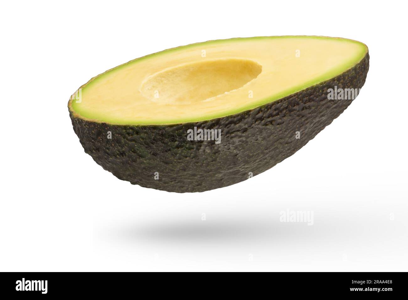 Flying fruits. Half of an avocado on a white isolated background ...
