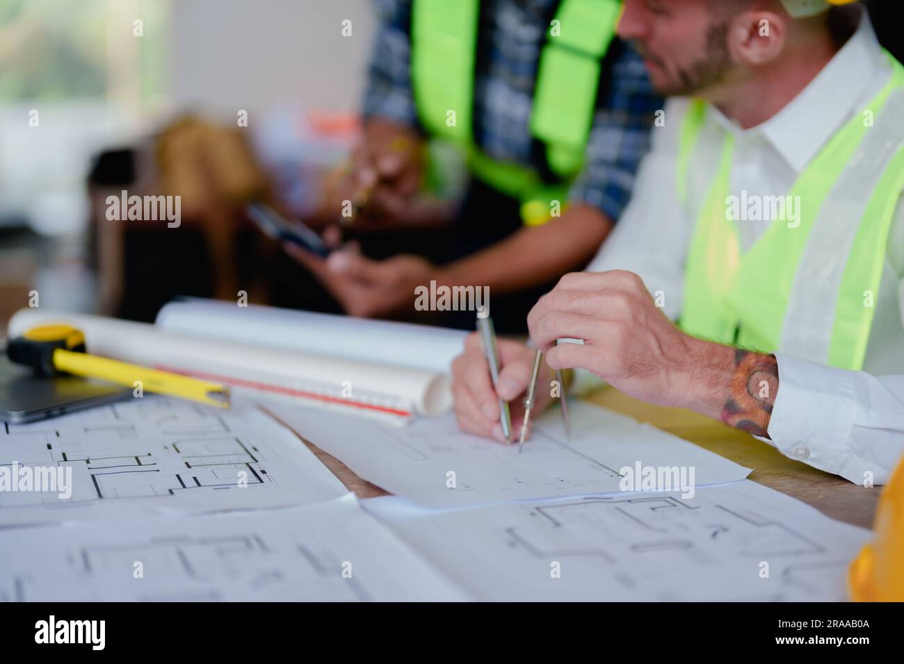 multi ethnic engineer brainstorming and measuring for cost estimating ...