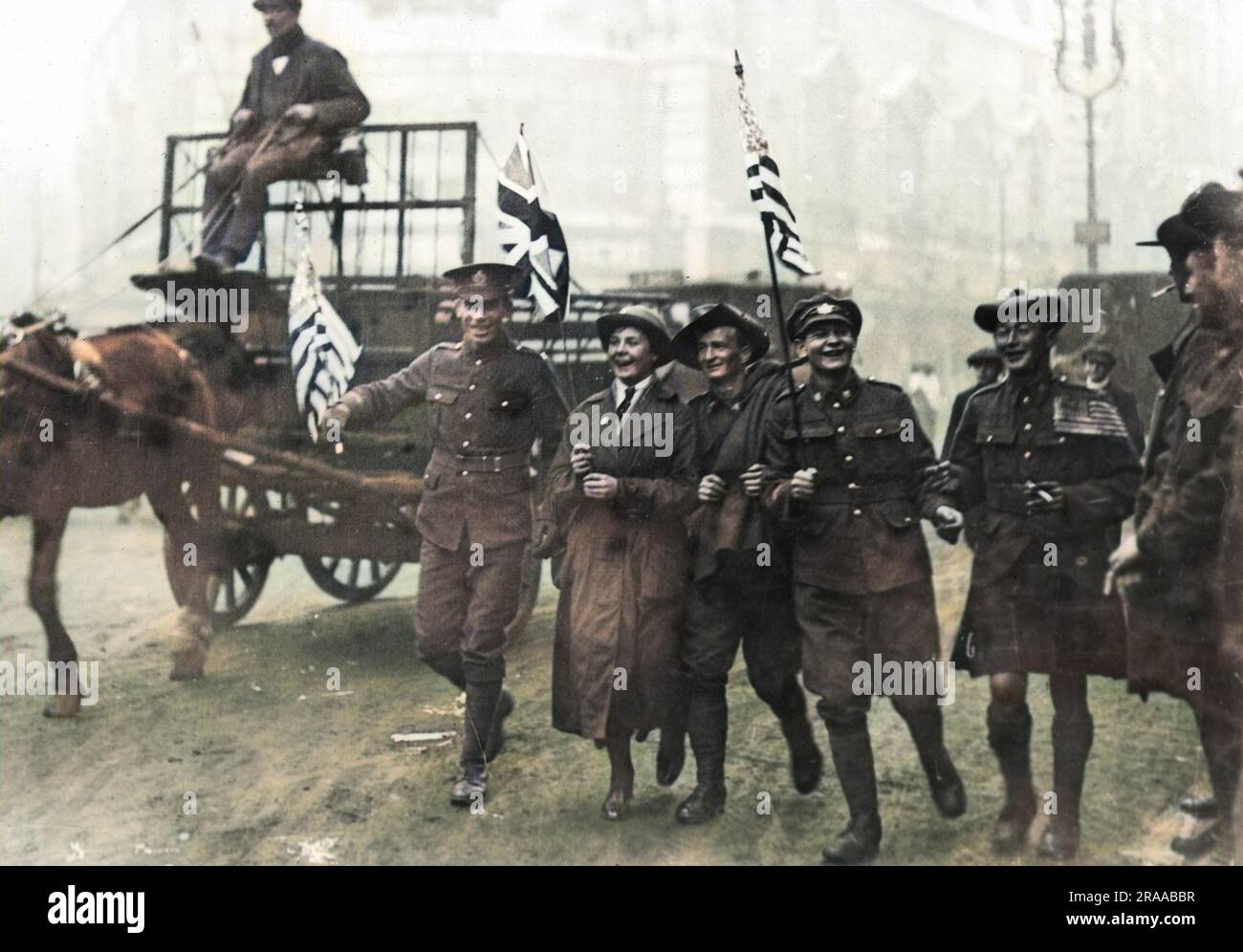 Armistice Day scene in London at the end of World War One: soldiers with British Union Jack and ...