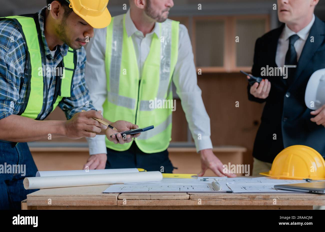 multi ethnic engineer brainstorming and measuring for cost estimating ...