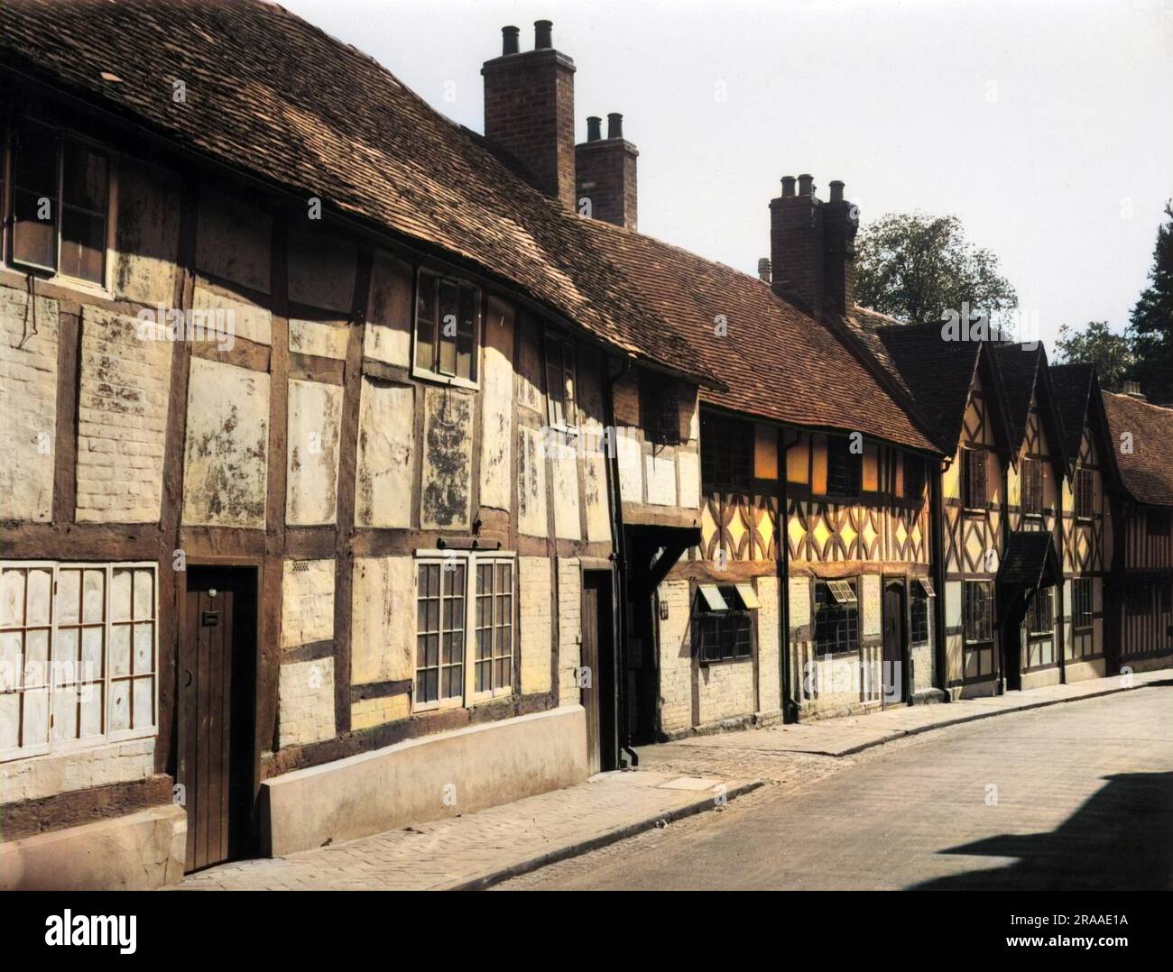 Mill Street, Warwick, with a row of Tudor half-timbered houses, a ...