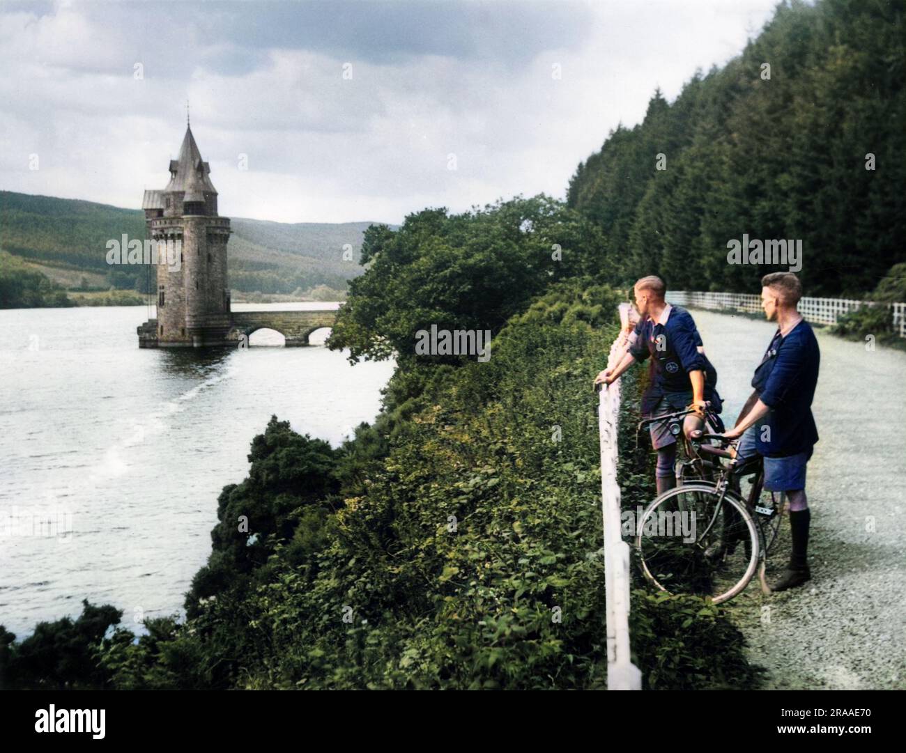 A tour cyclist admires the Control Tower of the Great Dam of Lake ...