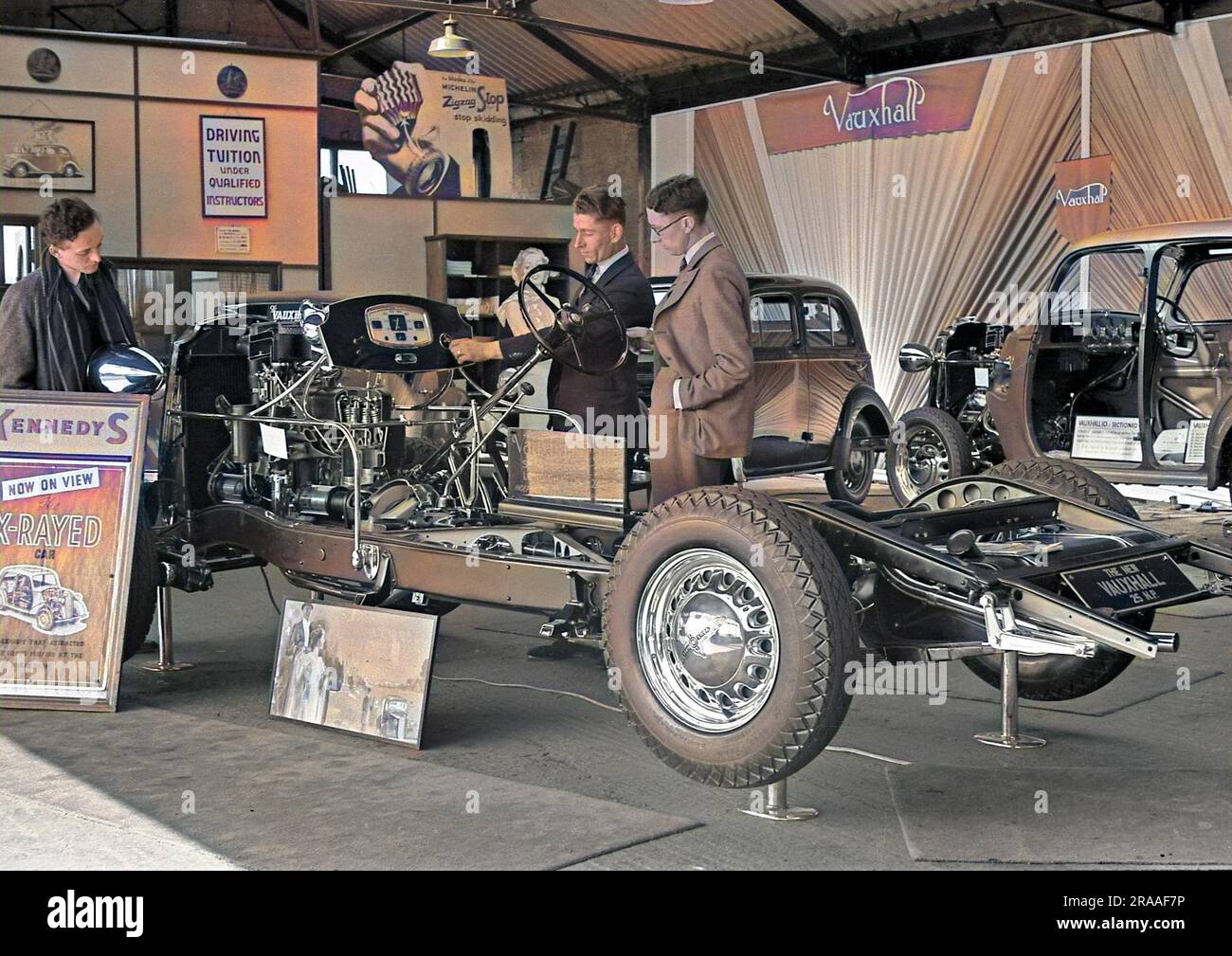 Scene in a car showroom, with a new Vauxhall 25 HP on display, stripped ...
