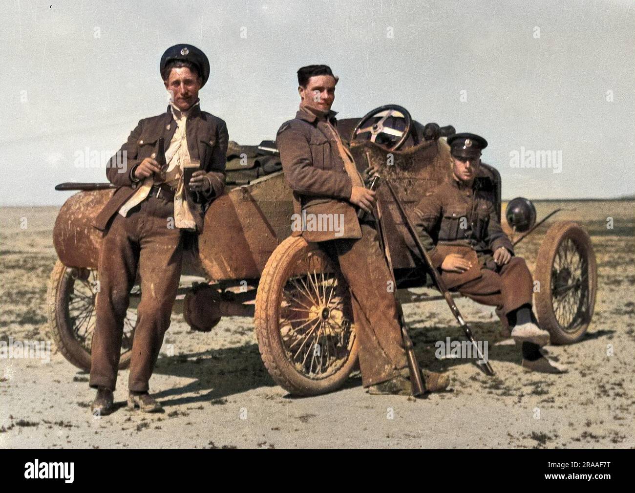 WW1 - Men in uniform drinking beer at the side of a car in a barren ...