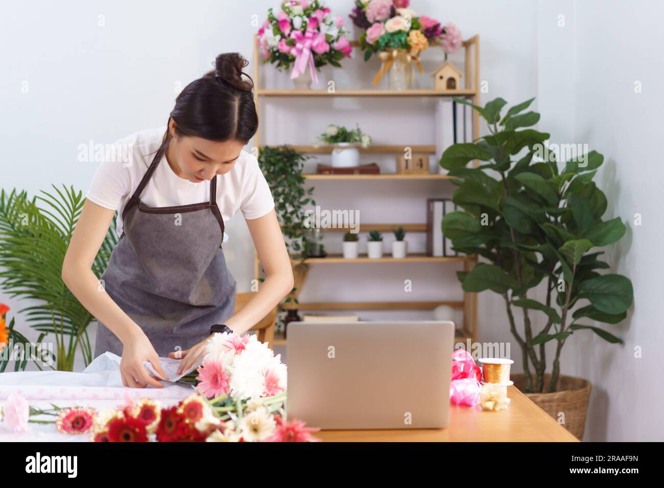 Flower shop concept, Female florist wrapping and creating colorful ...