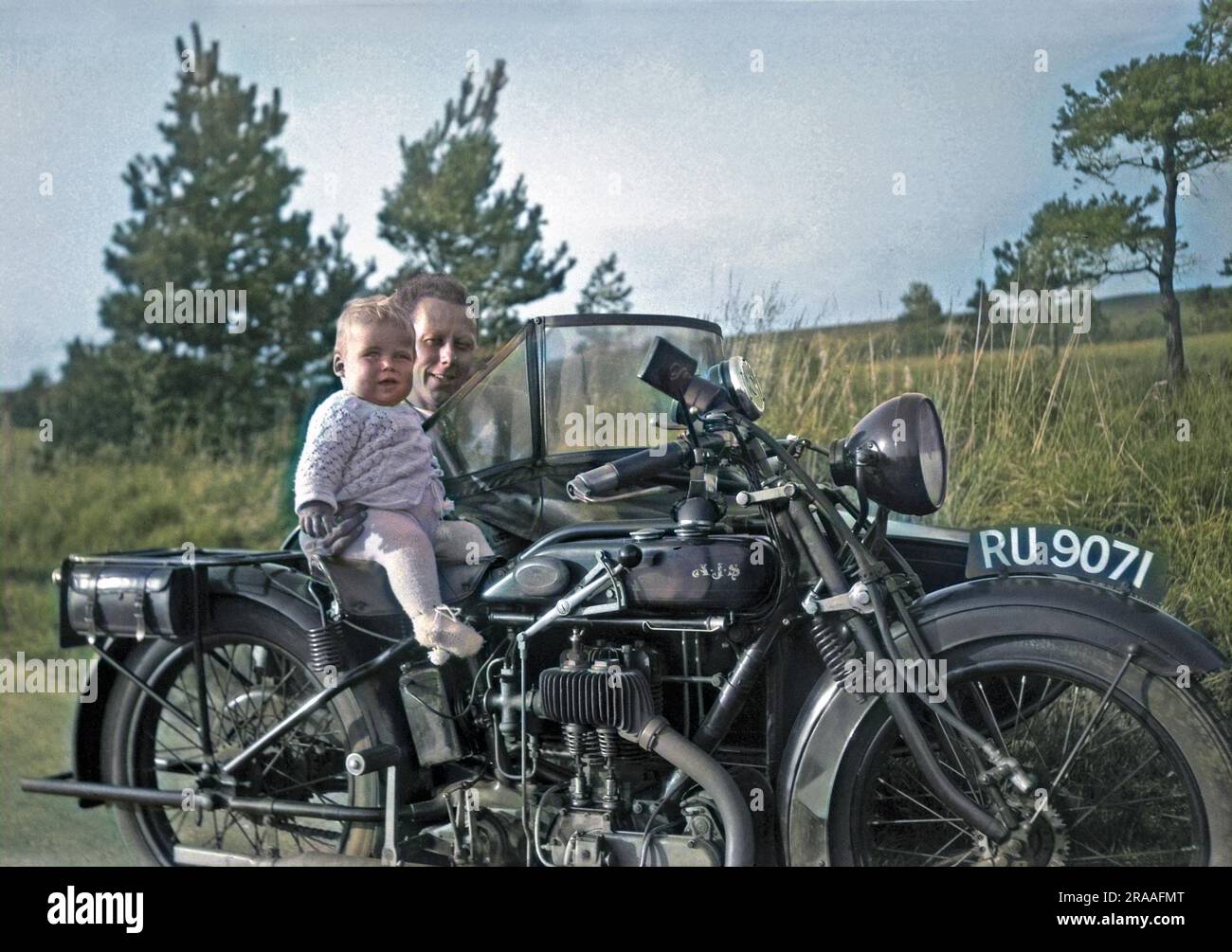 A man with a large motorbike and a baby. They seem to have swapped ...