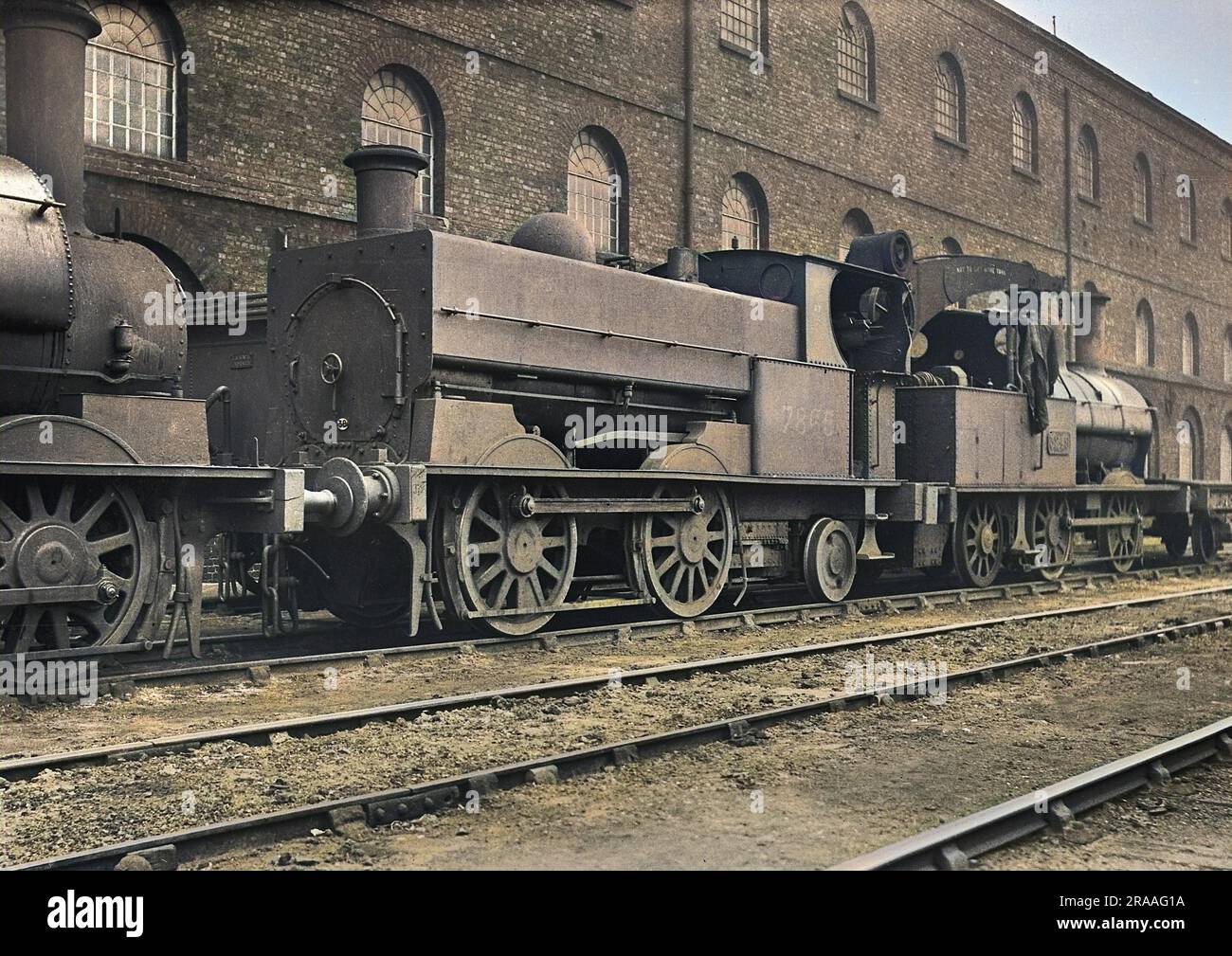 Steam engine with lifting equipment on a railway track at the side of a ...