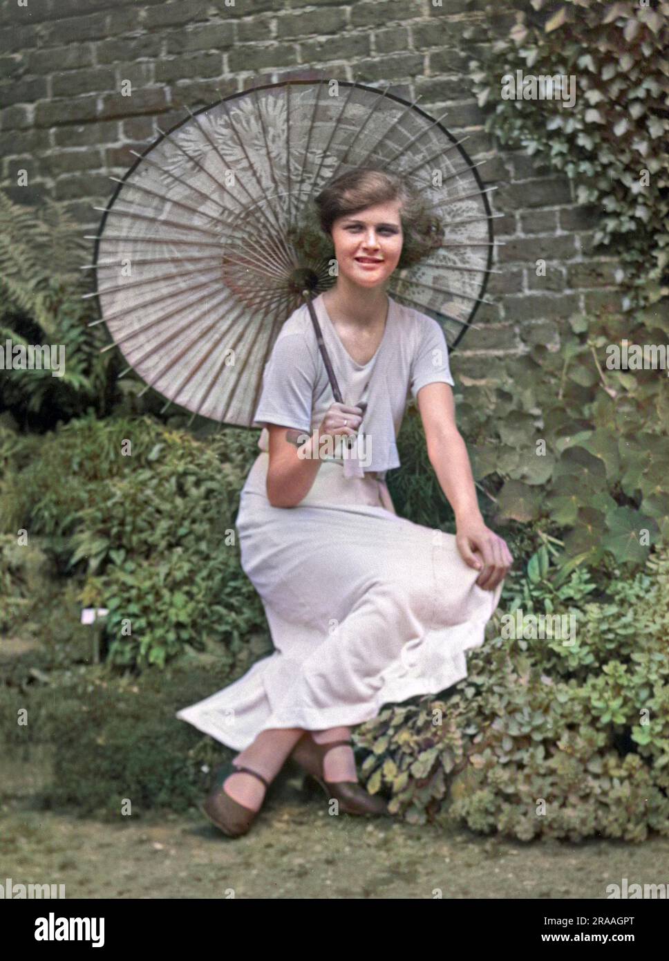 A young woman in a garden with a parasol. Date: 1935 Stock Photo - Alamy