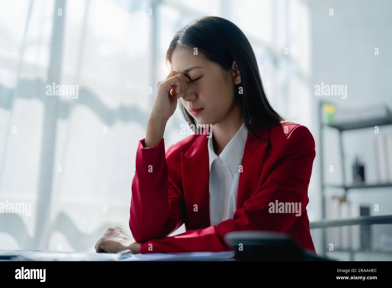 Portrait of a young Asian woman showing acute headache from sitting for ...