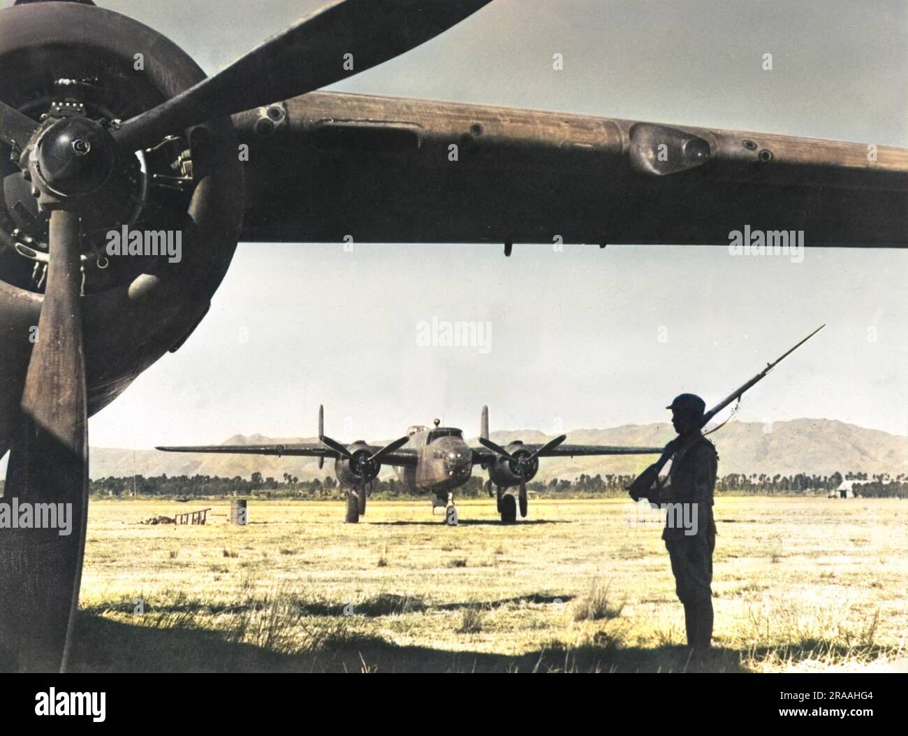 A Chinese sentry stands guard in the shadow of the wing of a bomber of ...
