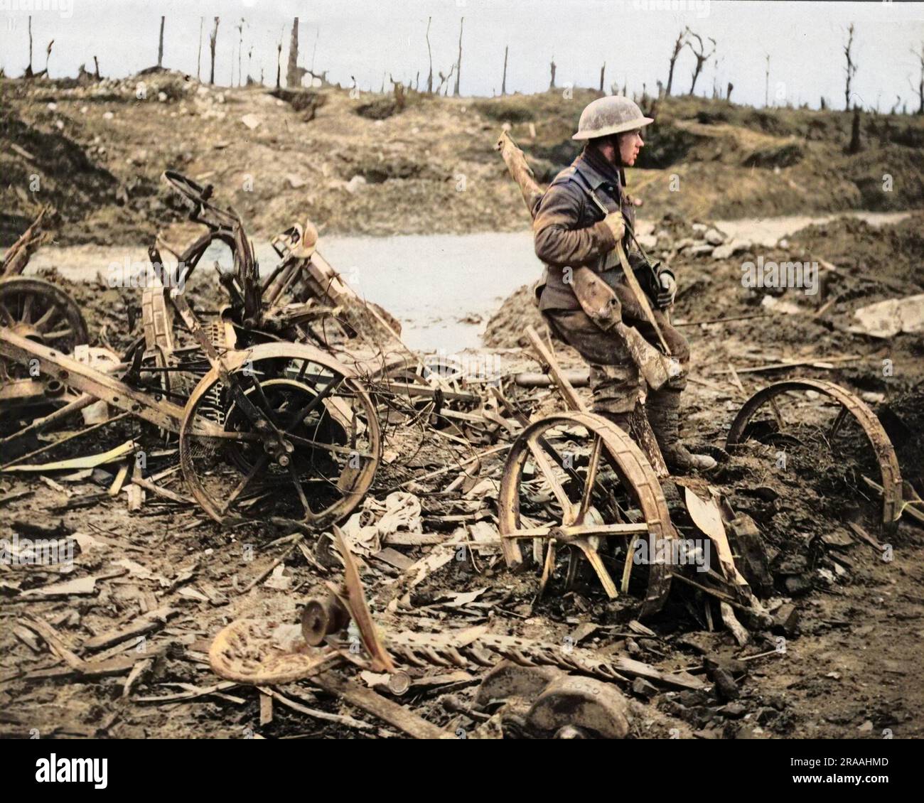 A British soldier waiting by some old farm machinery on the Western ...