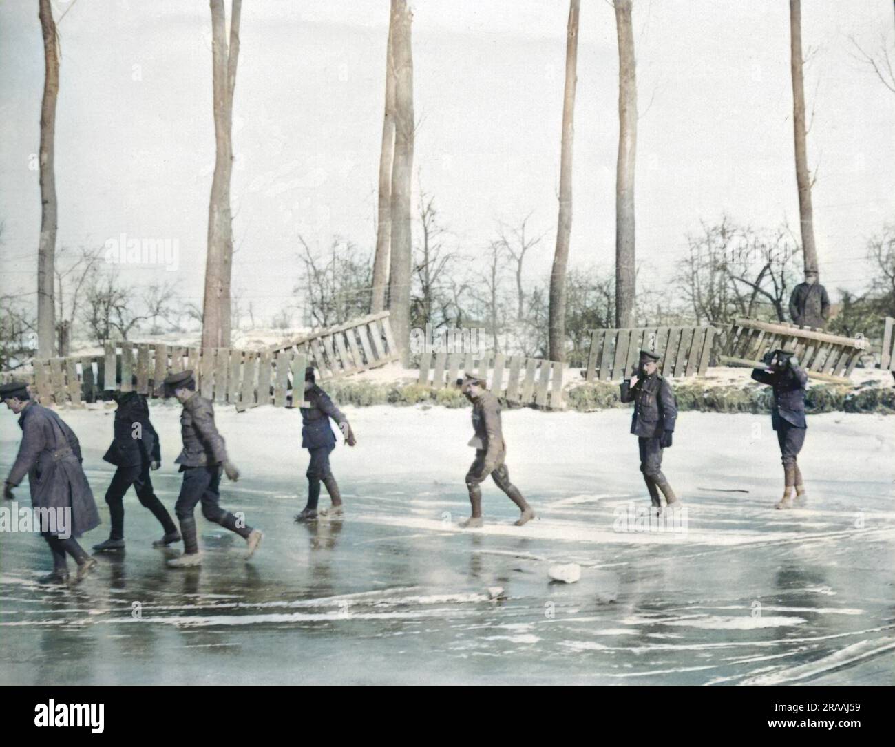 A British working party carrying wooden platforms across a frozen canal ...