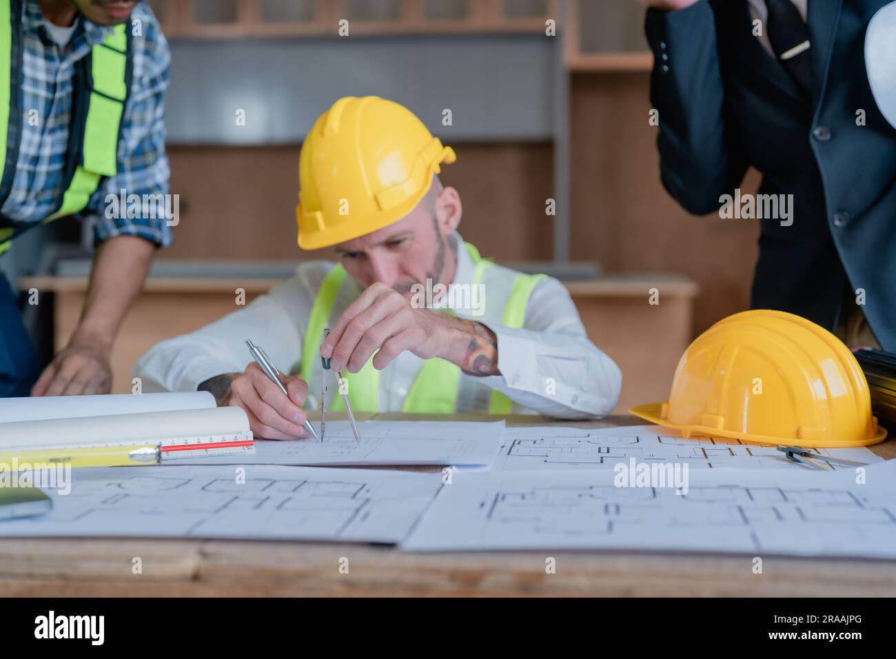 multi ethnic engineer brainstorming and measuring for cost estimating ...